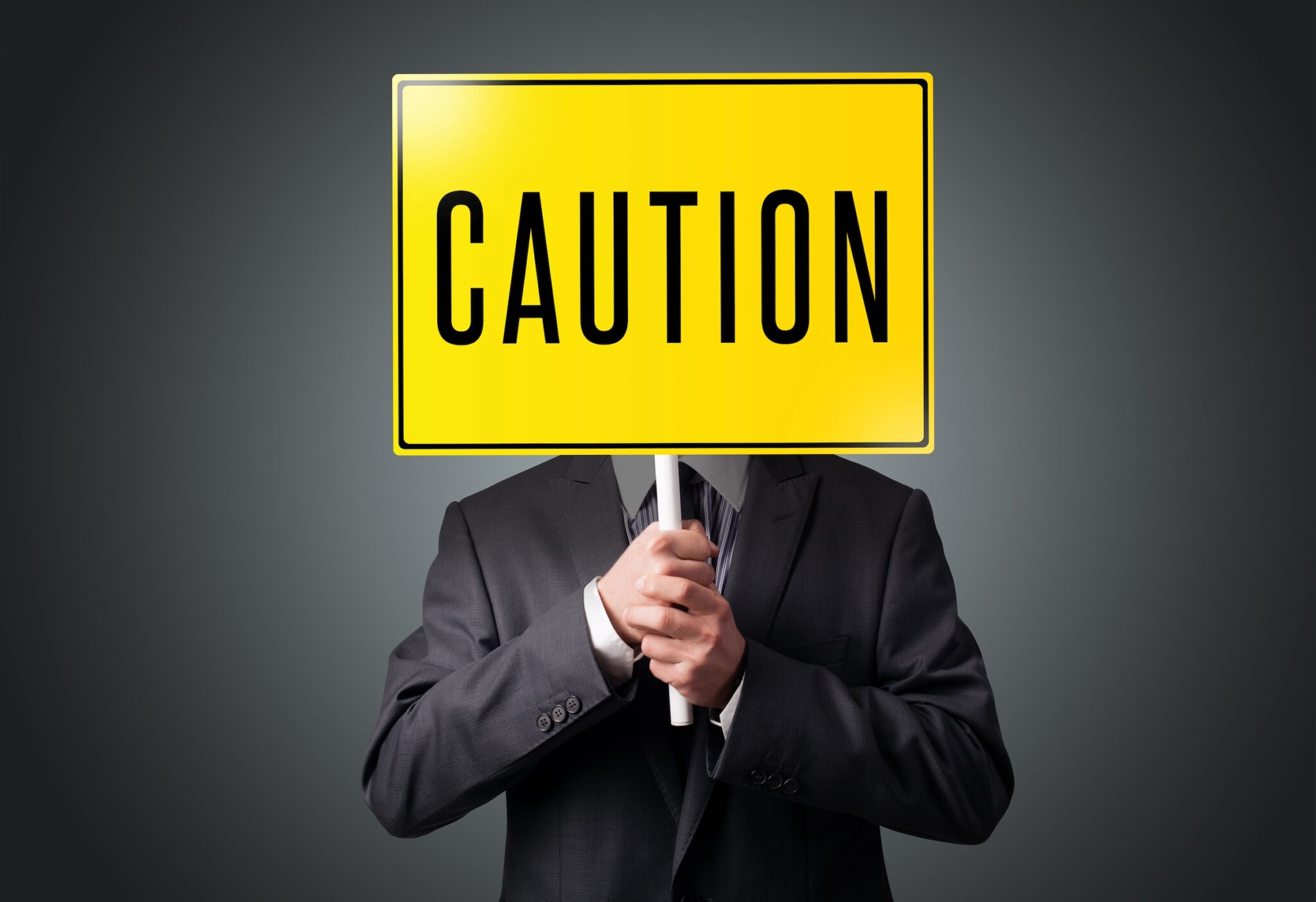 man holding caution sign - GrassrootsHealth
